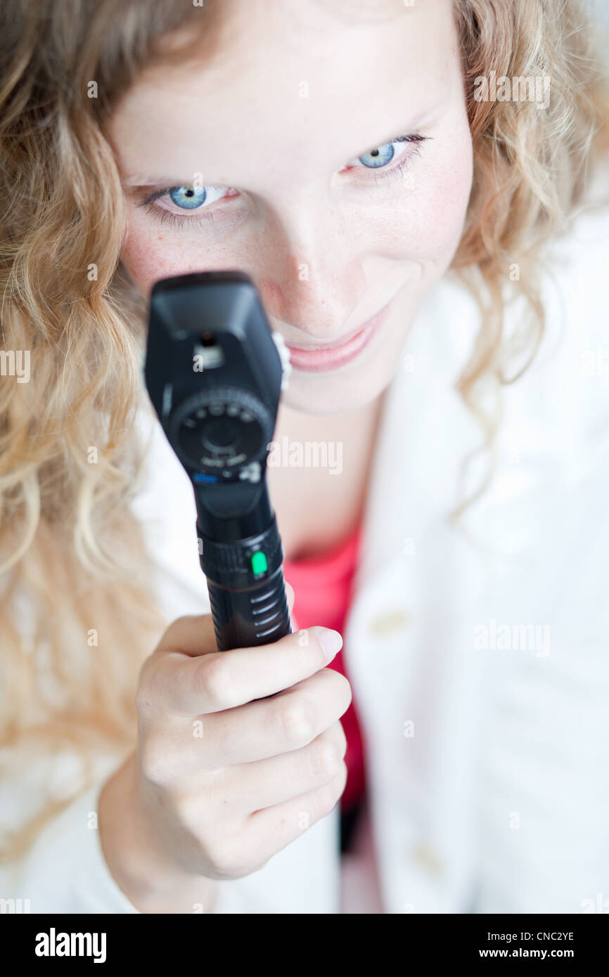 pretty female doctor/optometrist checking your eyes with an ...