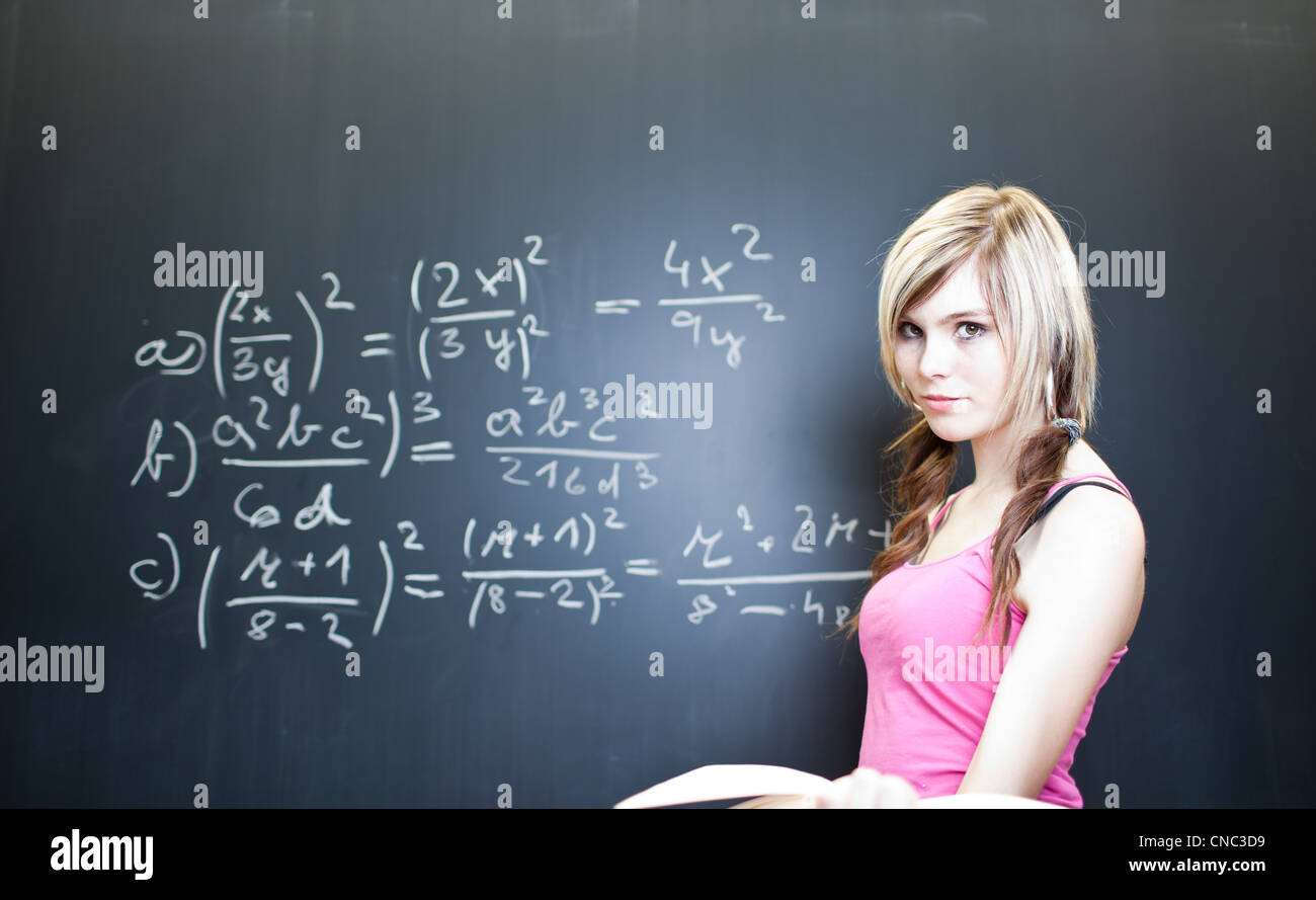 pretty young college student writing on the chalkboard/blackboard ...