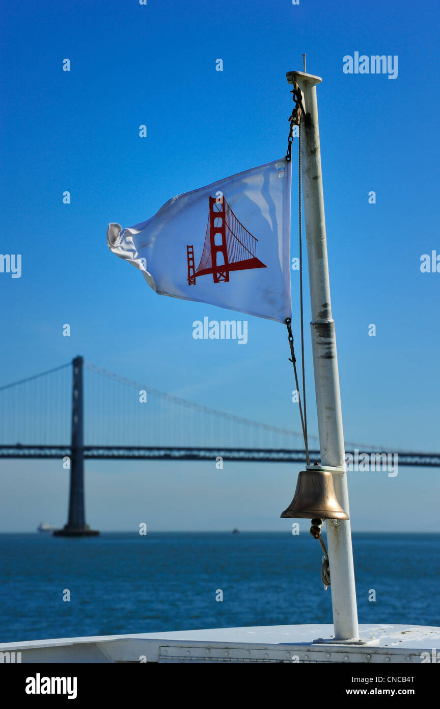 Two landmarks - a Golden Gate Bridge flag in front of the Bay Bridge ...