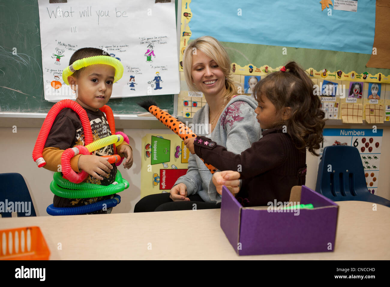Preschool teacher with boy and girl students in the classroom Stock ...