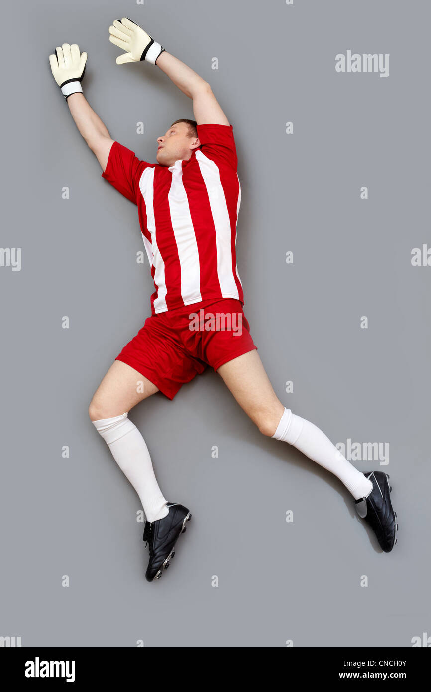 Goalkeeper jumping high to catch the ball Stock Photo - Alamy