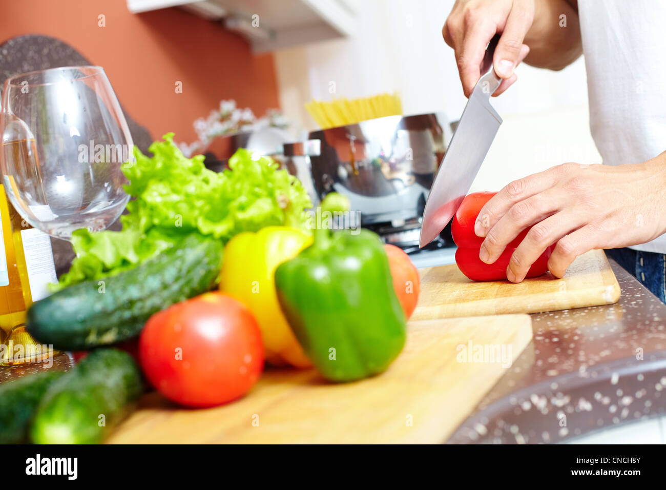 Close-up of young man cutting vegetables in the kitchen Stock Photo - Alamy