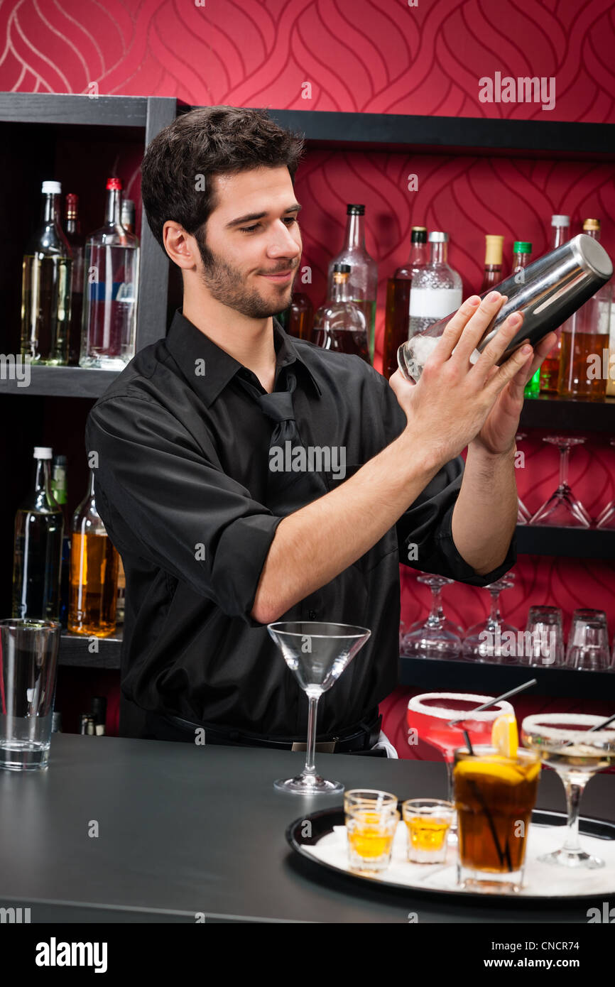 Handsome barman professional at posh bar making cocktail drinks Stock ...