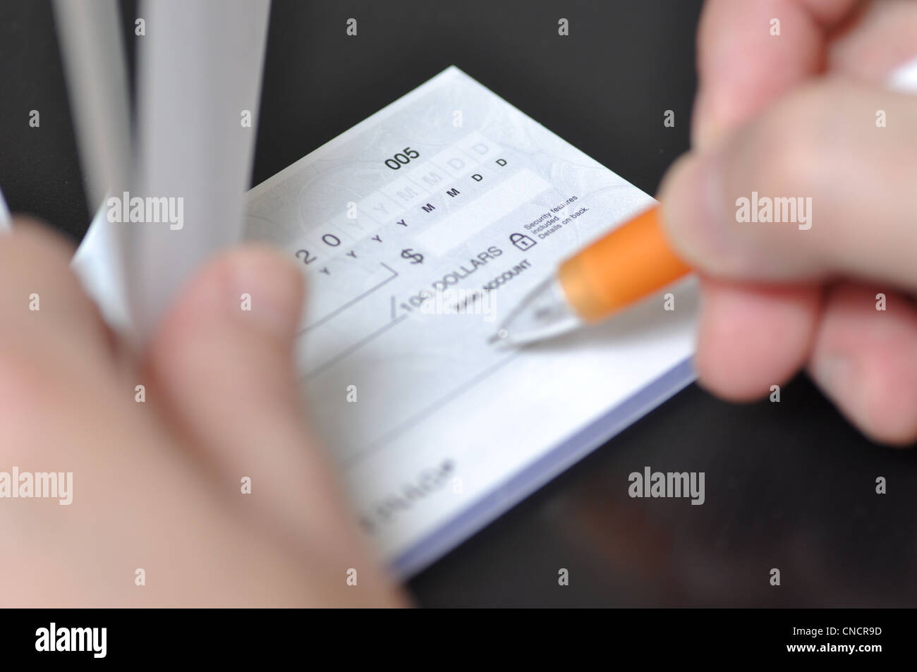 Man hold a pen to write check Stock Photo - Alamy