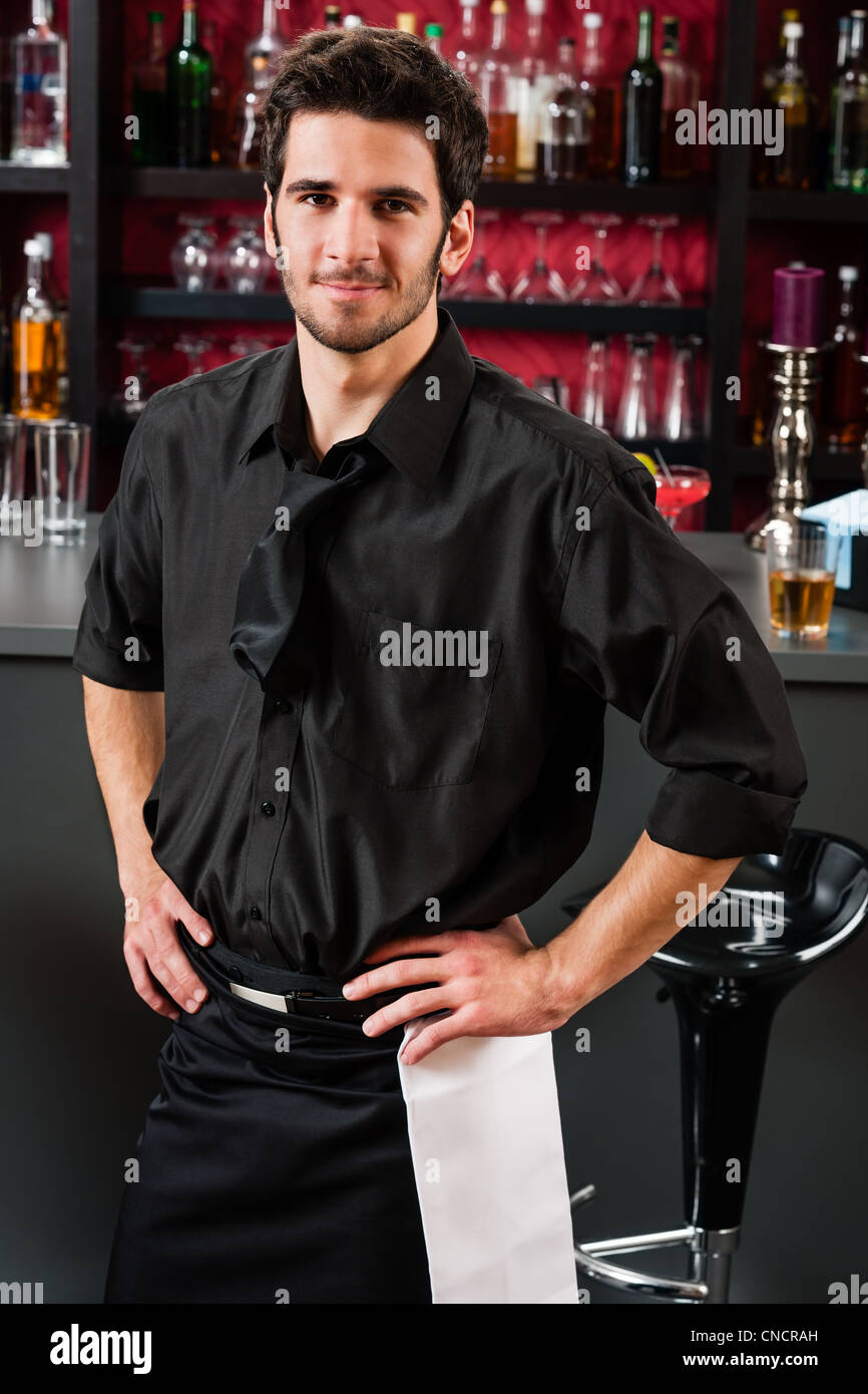 Portrait of handsome barman standing in front of the bar Stock Photo ...