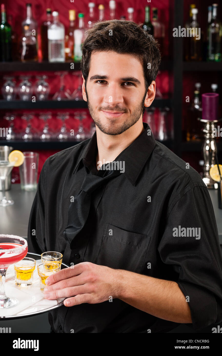 Portrait of handsome barman at bar holding tray with cocktails Stock ...