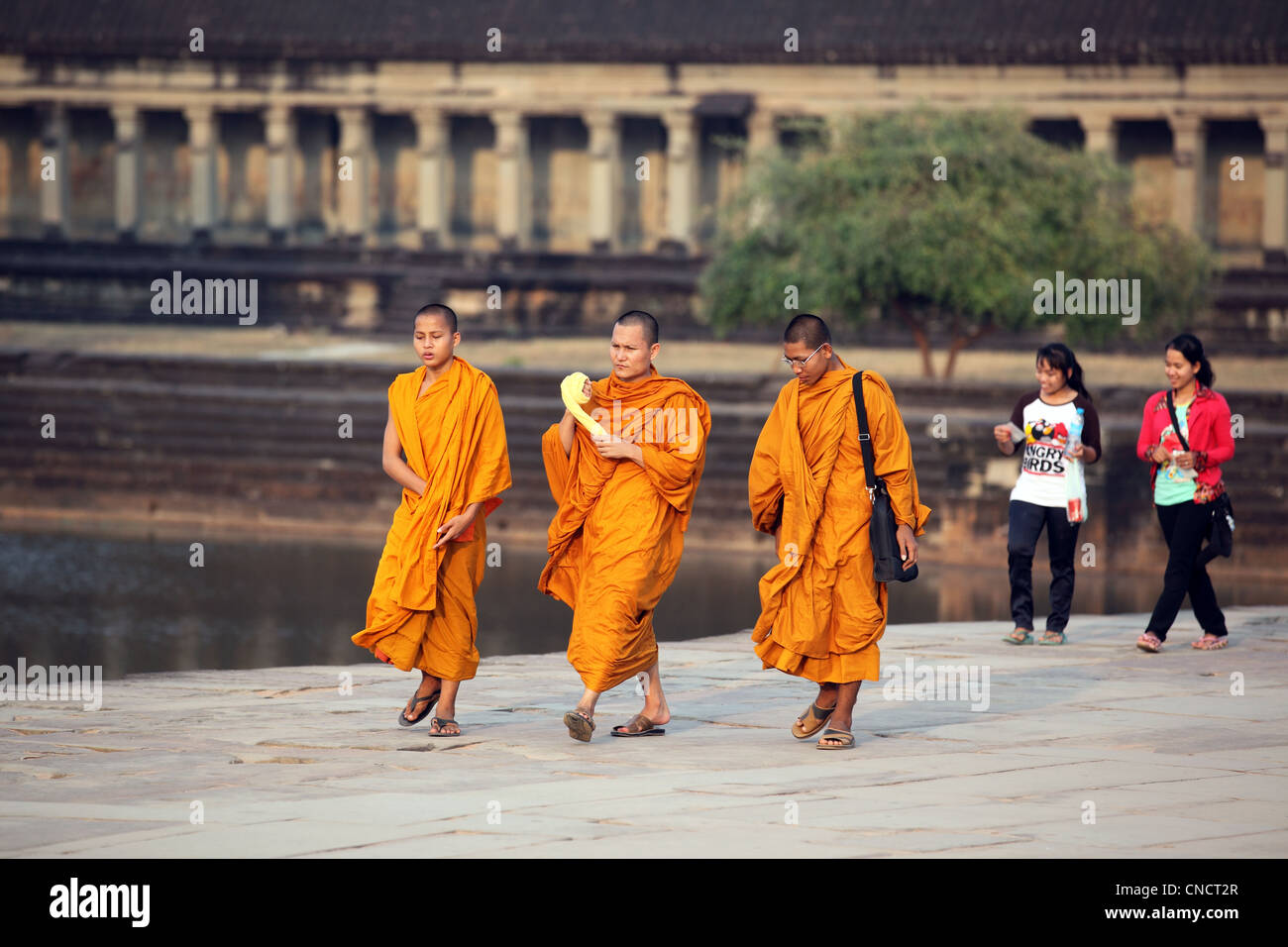 Buddhist monks walking across the mote bridge at Angkor Wat Temple ...