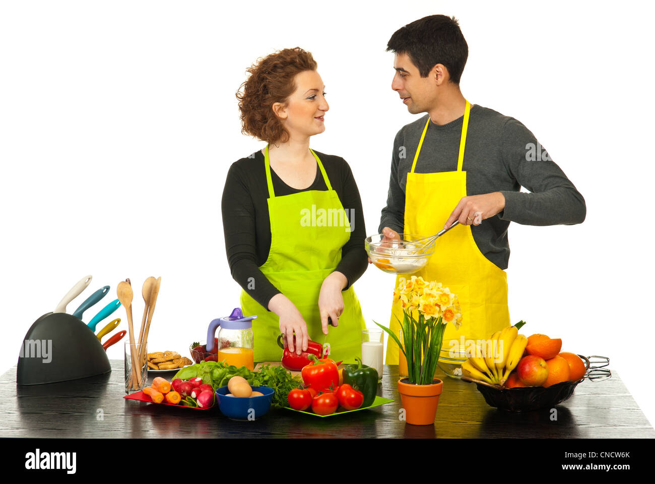 Happy couple cooking together and having conversation against white ...