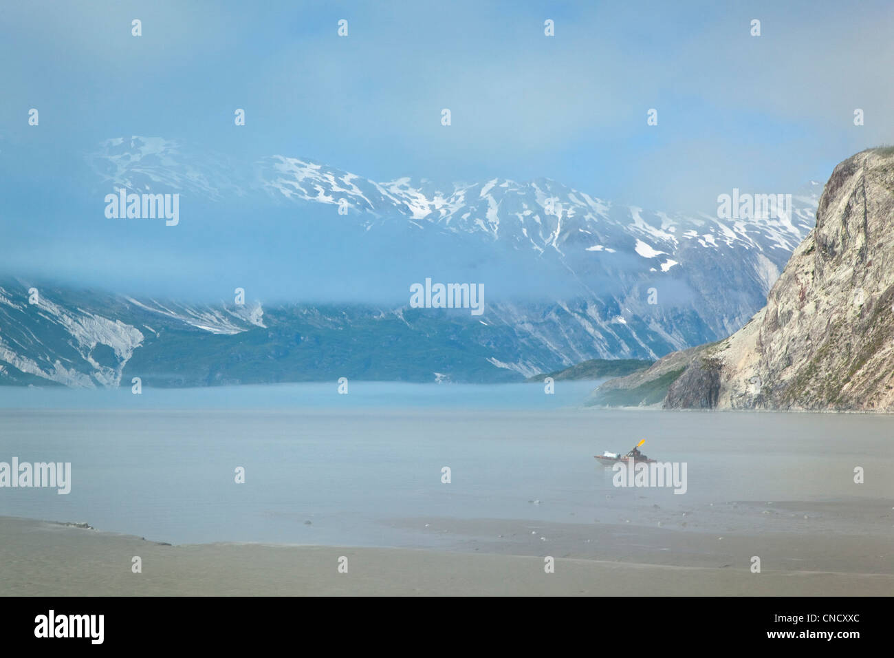 A kayaker paddles through the mist in Muir Inlet, Glacier Bay National ...