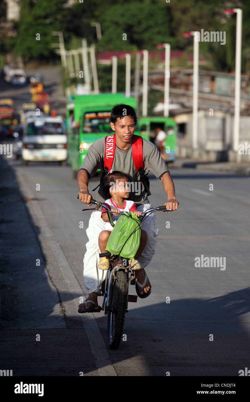Father and daughter on bicycle. Tagbilaran, Bohol Island, Bohol ...