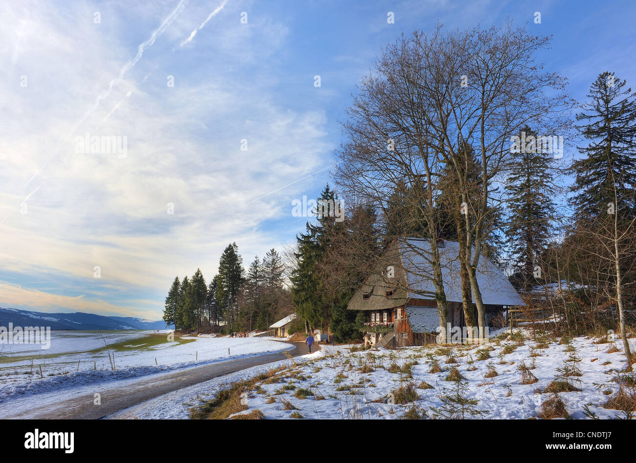 An idyllic winter scene of a farmhouse set in a snowy landscape near ...