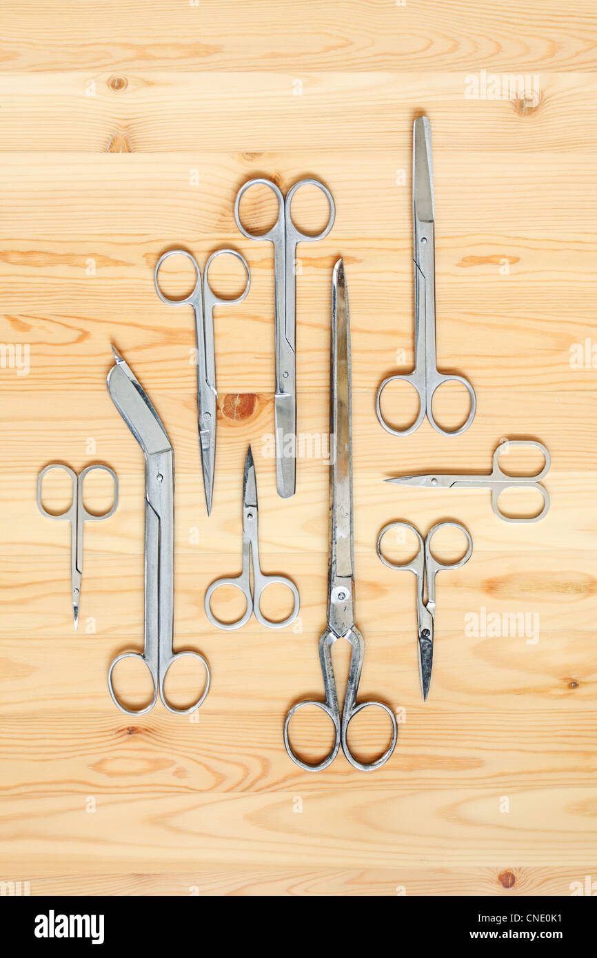 Different types of scissors lying on wooden surface Stock Photo - Alamy