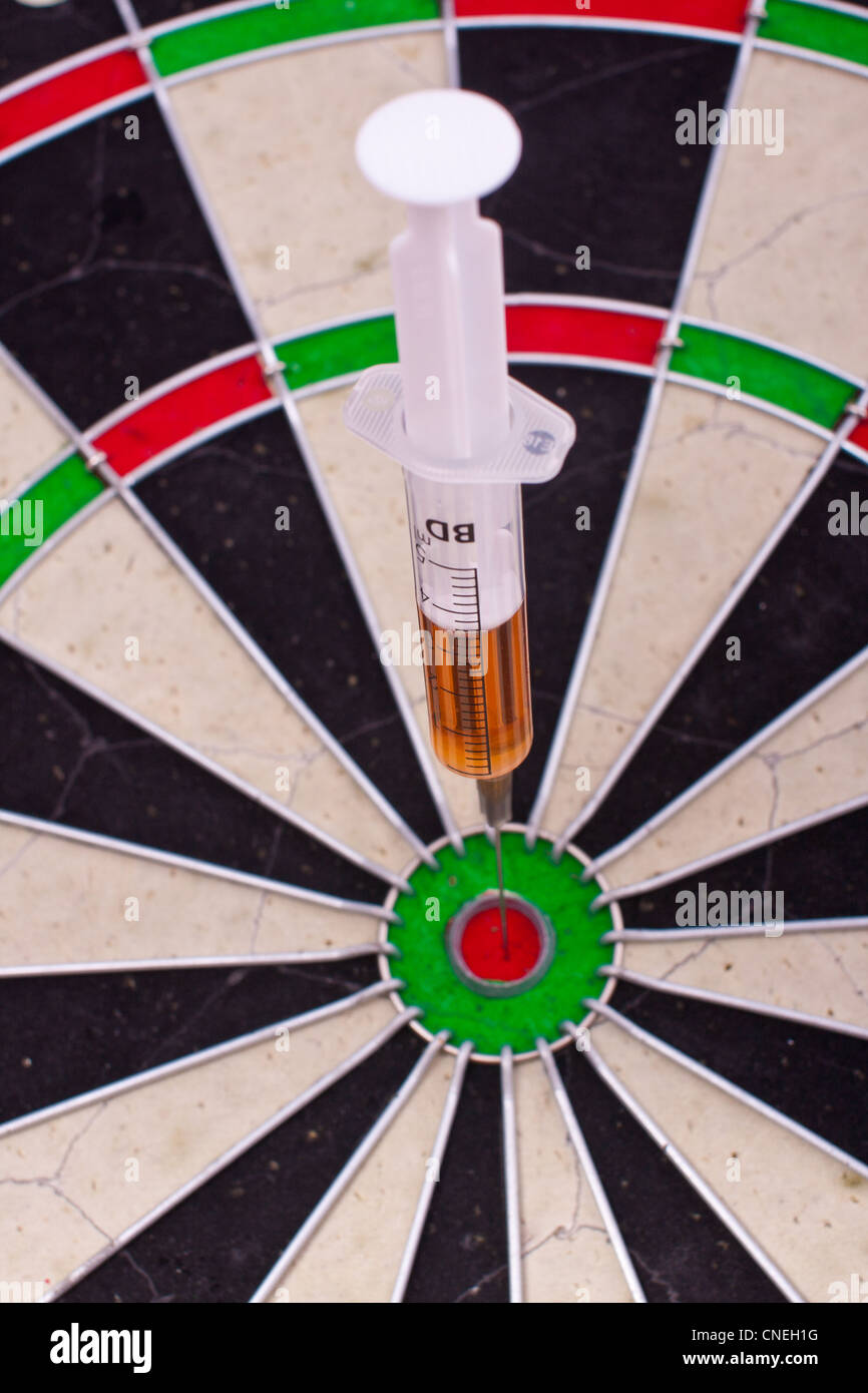 syringe in target on darts board Stock Photo - Alamy