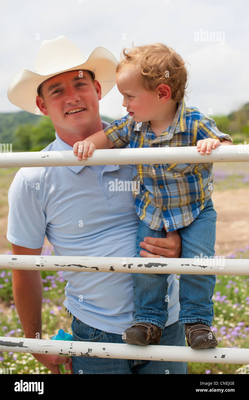 Cowboy father and his son behind horse panel Stock Photo - Alamy
