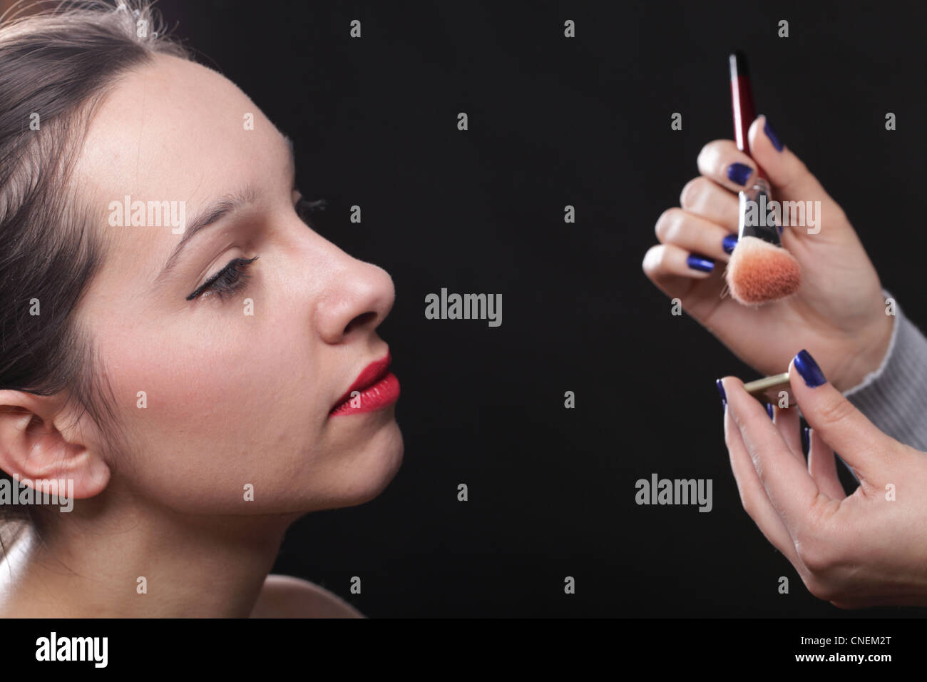 beautiful young brunette woman applying powder with a brush black ...
