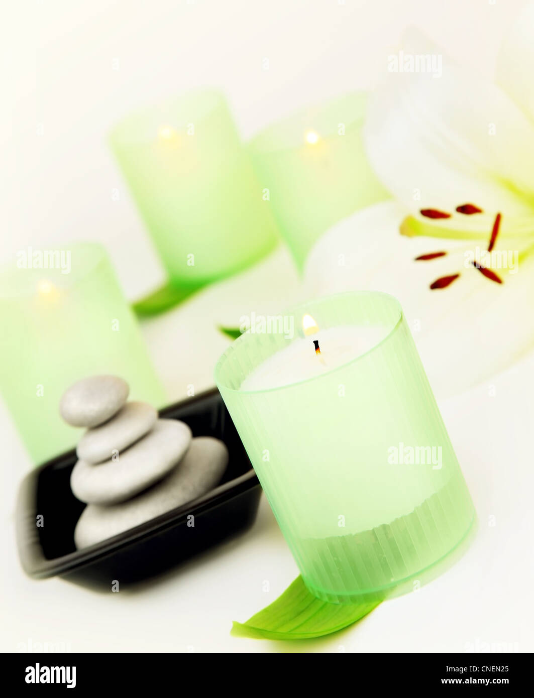 Candles and balanced zen spa stones with lily flower, relaxation ...