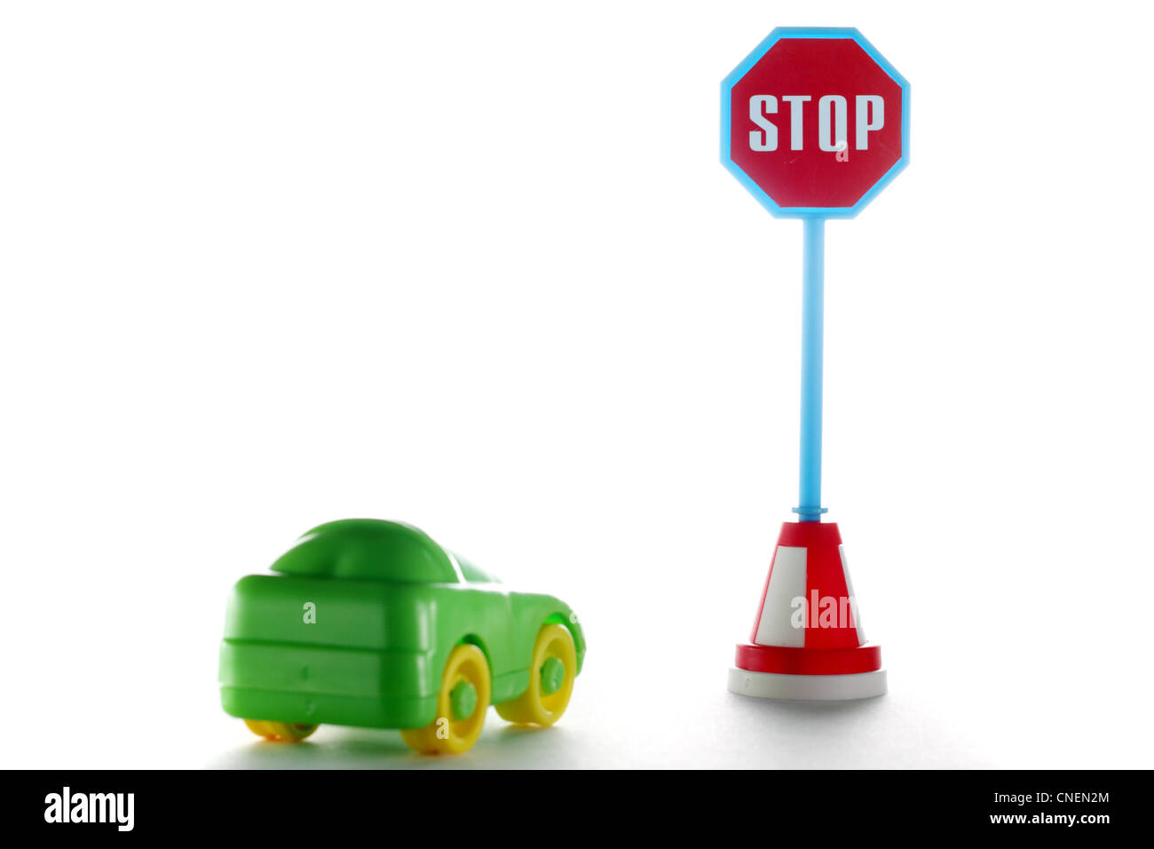 Car behind stop road sign on a white background Stock Photo - Alamy