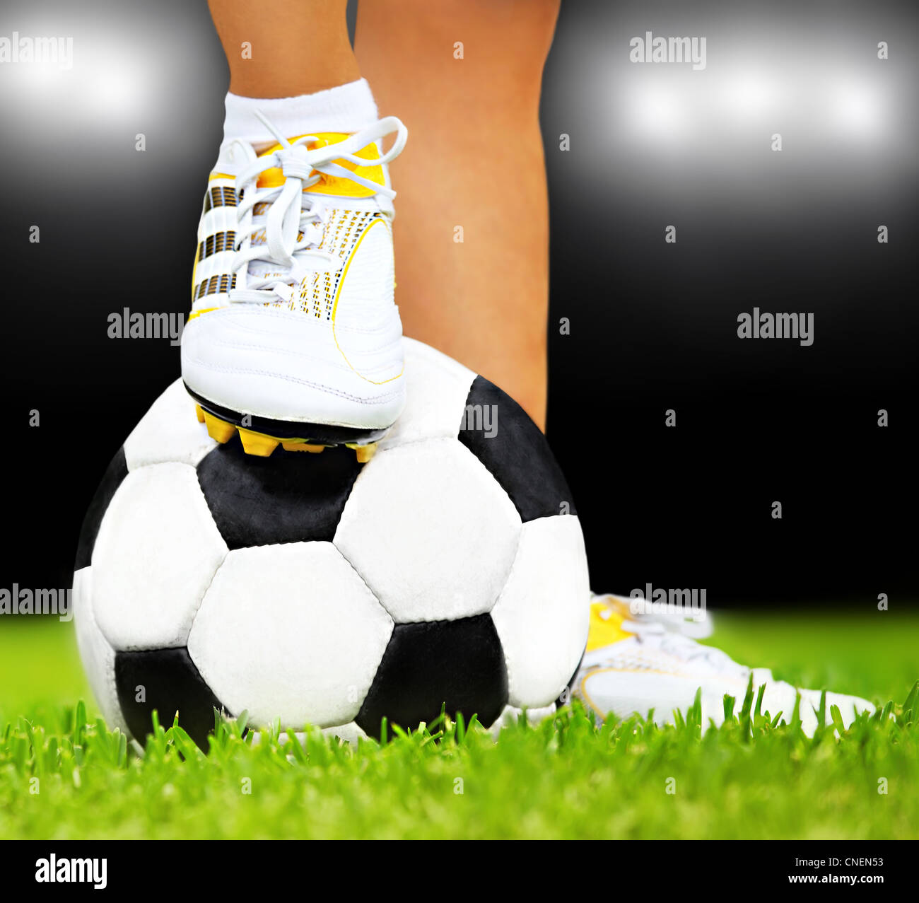 Football player feet on the ball, playing sport outdoor at night ...
