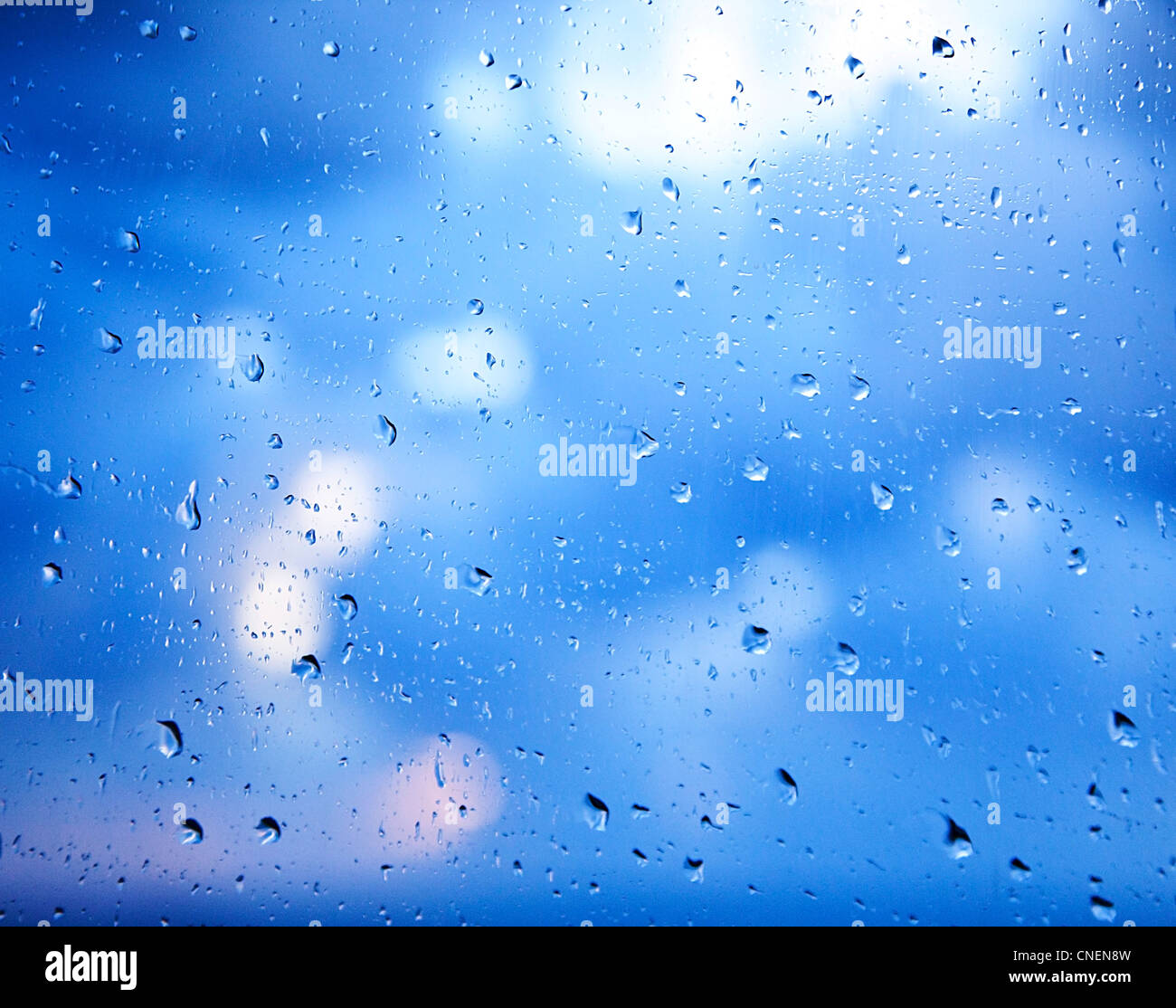 Window glass with raindrops, blue abstract background over blue ...
