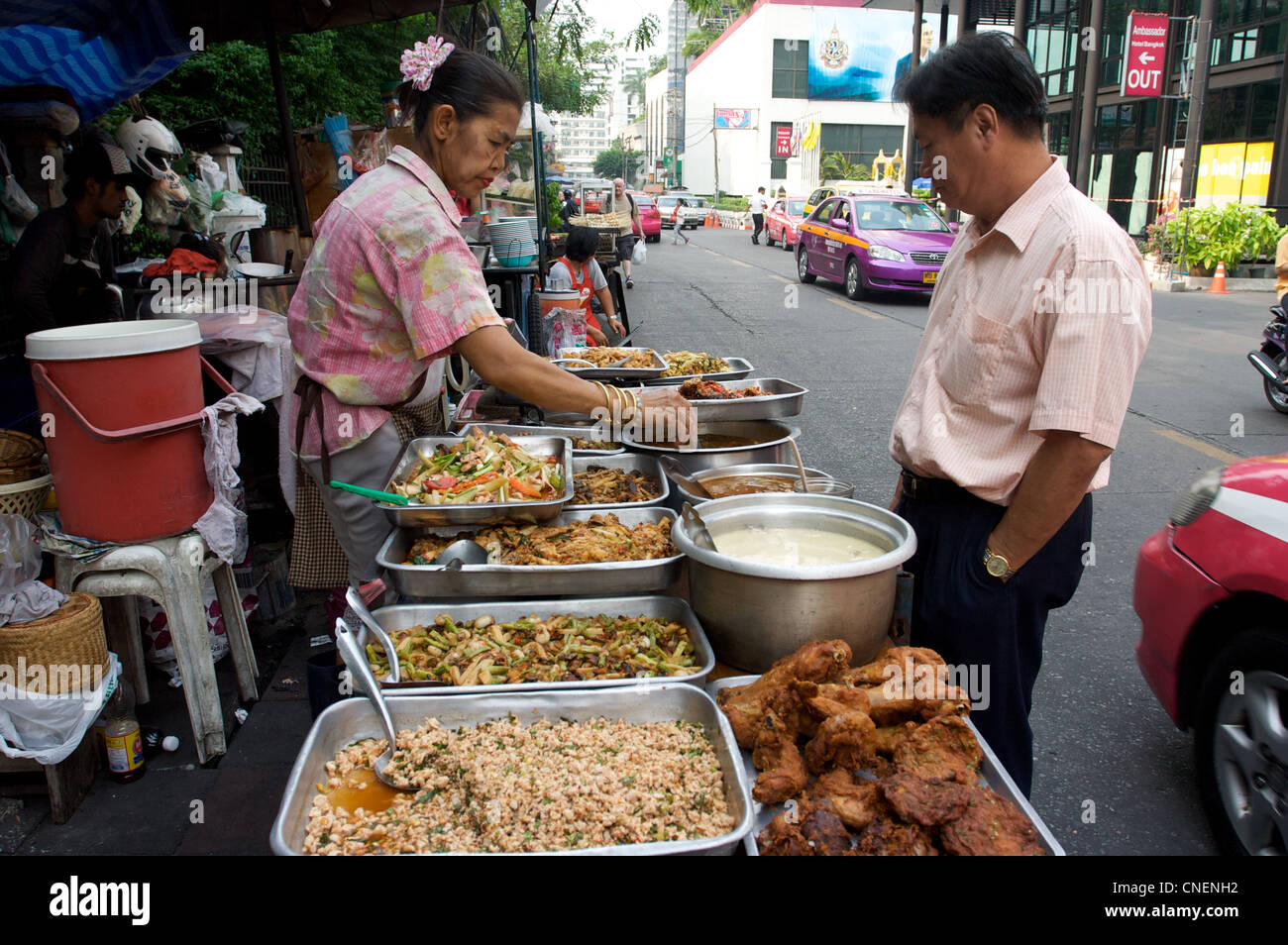 Bangkok street food stalls on the roadside, many local dishes on trays ...