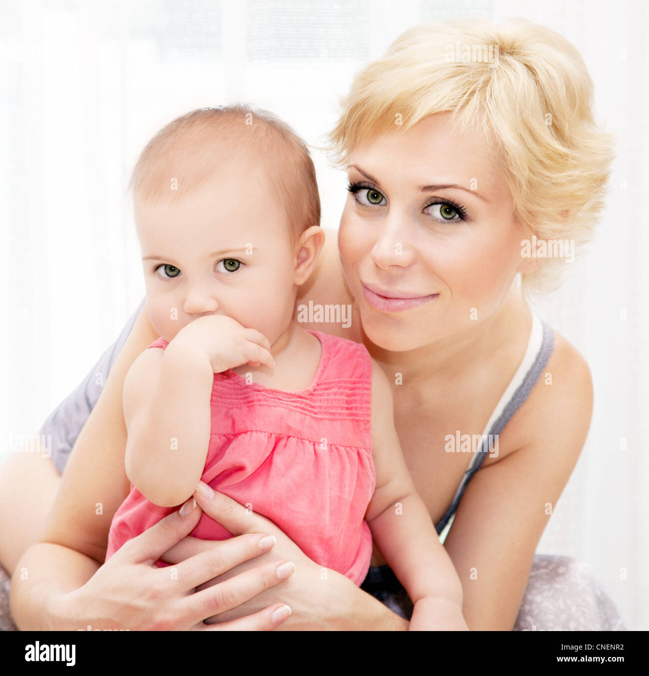 Portrait of a happy young mother holding baby girl, cute family at home, loving mom Stock Photo ...