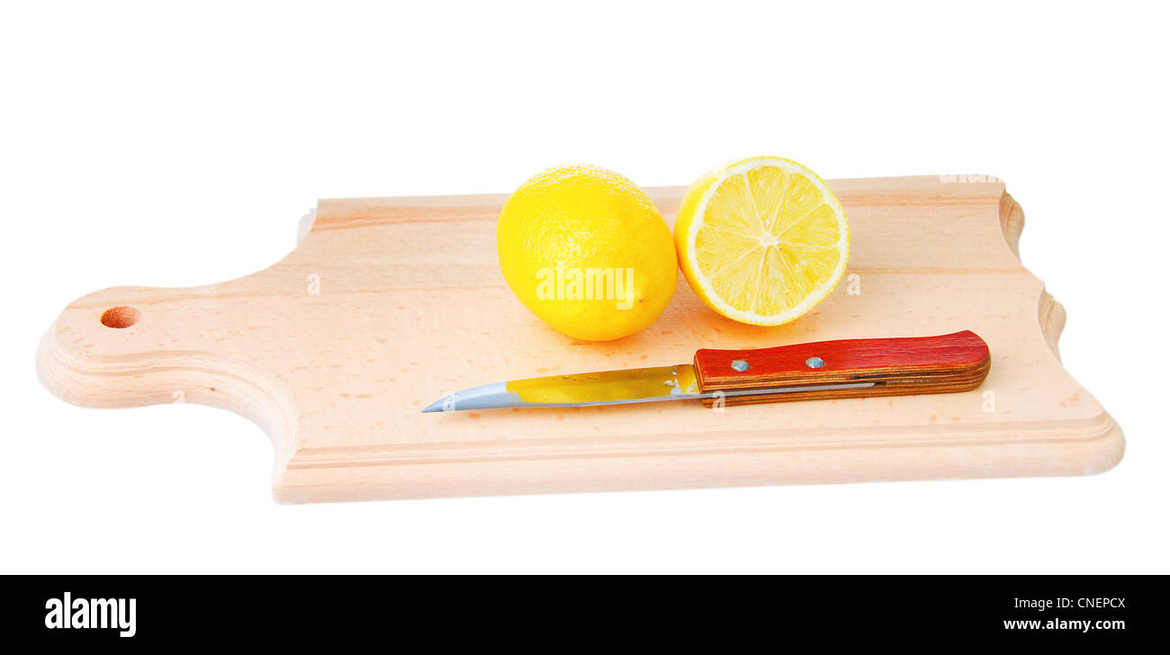 One whole lemon and one cutted lemon with knife on wooden plank ...