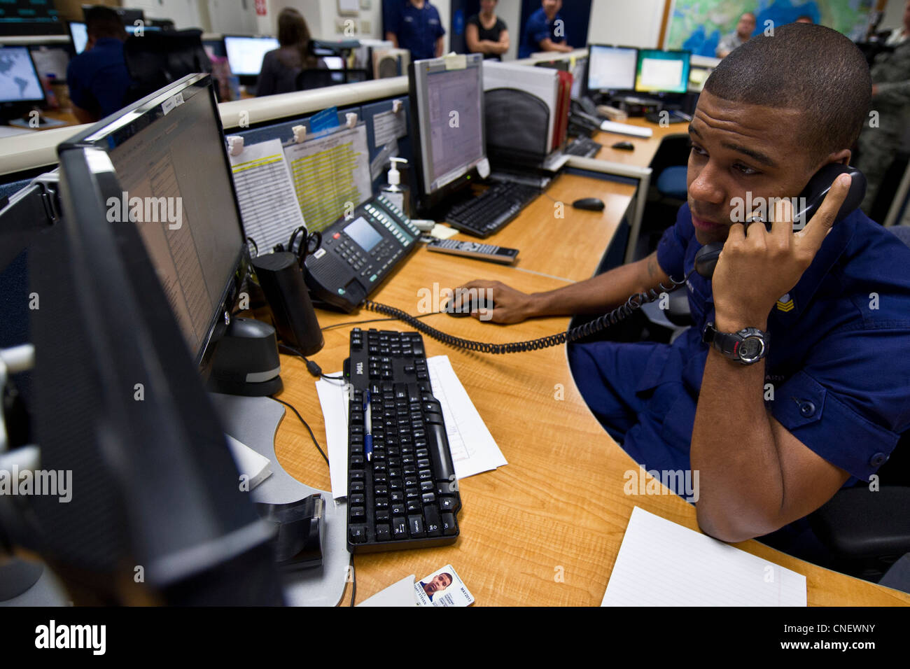 U.S. Coast Guard Operations Specialist 1st Class Gary Smedley answers a ...