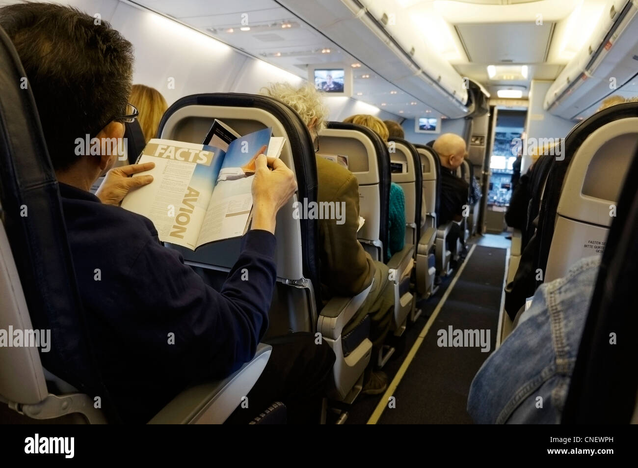 Man on an Airplane reading an Inflight Magazine Stock Photo - Alamy