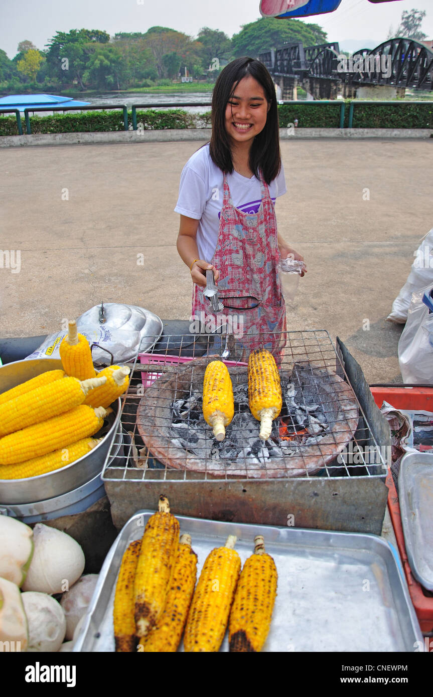 Girl grilling corn on stall by The Bridge over the River Kwai ...