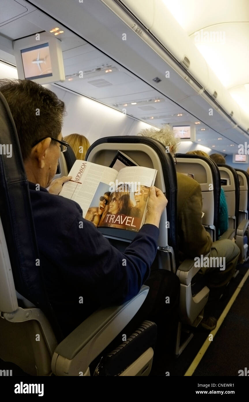 Man on an Airplane reading an Inflight Magazine Stock Photo - Alamy