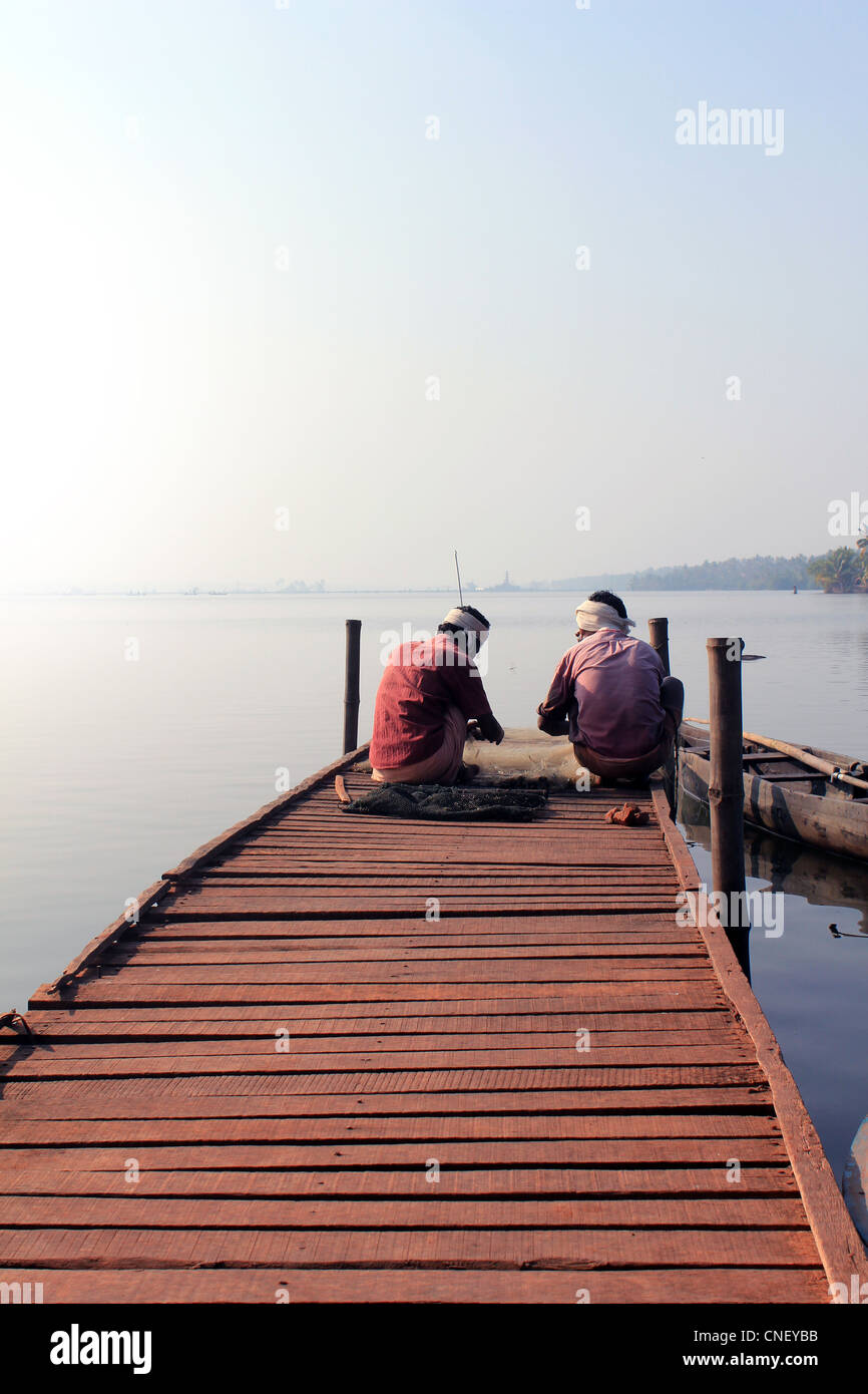 Fishermen sitting on a wooden platform with the fish catch in early ...