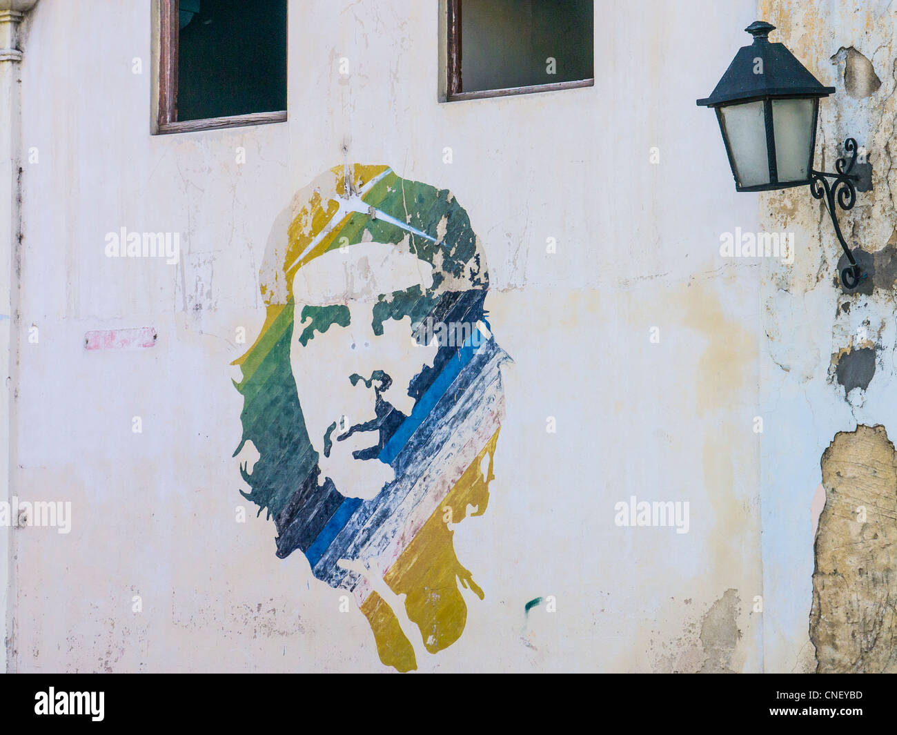 A multi-colored painted picture on a wall of the face of the ...