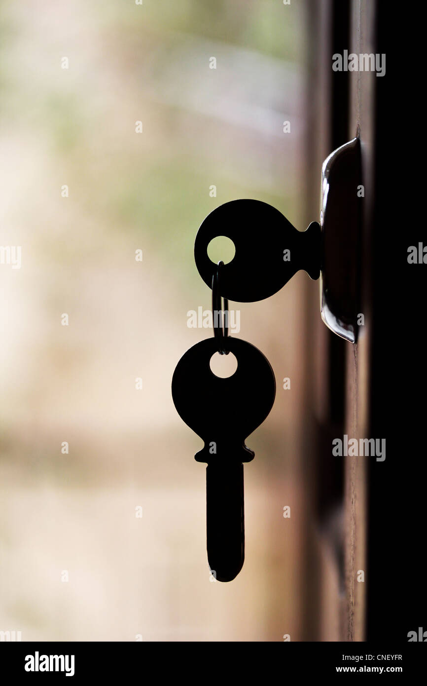 Silhouette of door keys hanging on the open door with blurred ...