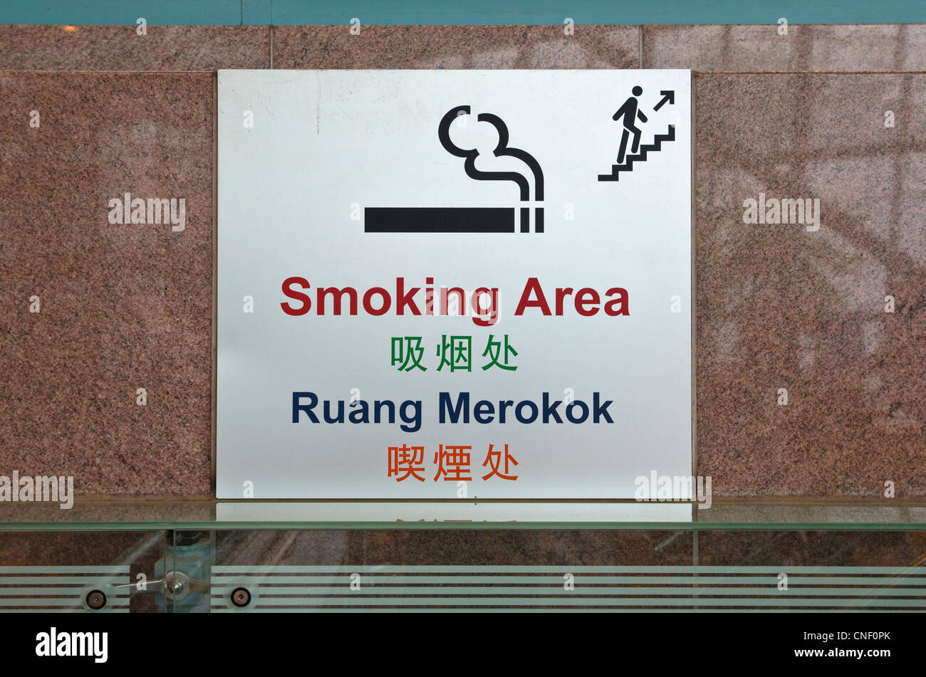 Multi-lingual sign indicating the direction of a designated smoking ...