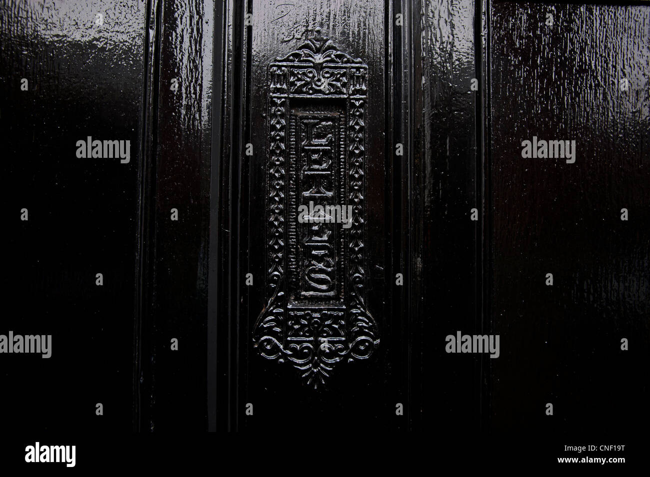 Black painted letterbox in a black painted door Stock Photo - Alamy