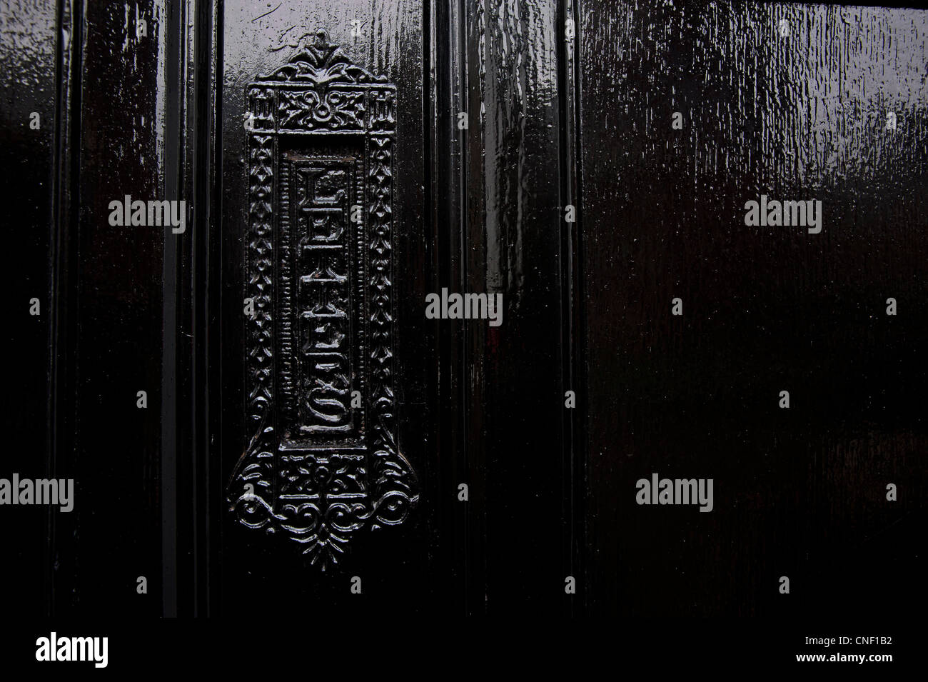 Black painted letterbox in a black painted door Stock Photo - Alamy