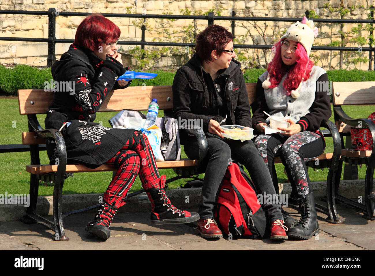 Three teenage girls eating lunch on a park bench, London. UK Stock ...