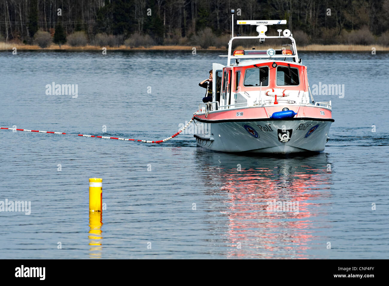 German water rescue patrol boat laying guide rope in the Chiemsee lake ...