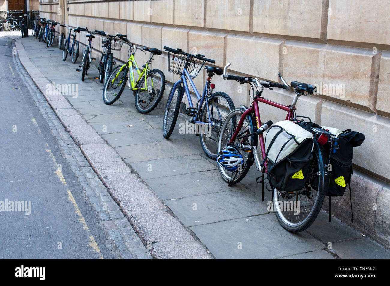 Line of bicycles leaning against a wall near Trinity Hall Cambridge ...