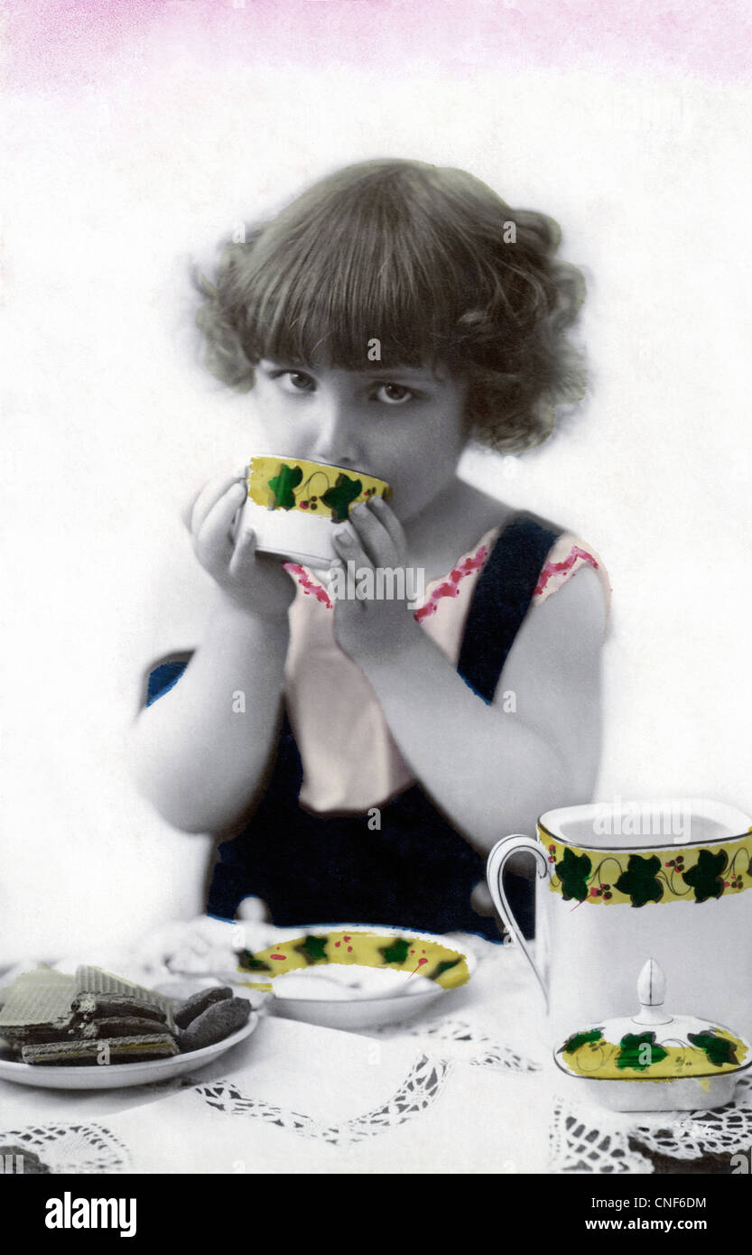 Young girl drinking tea from a decorated set of china, circa 1923 Stock ...