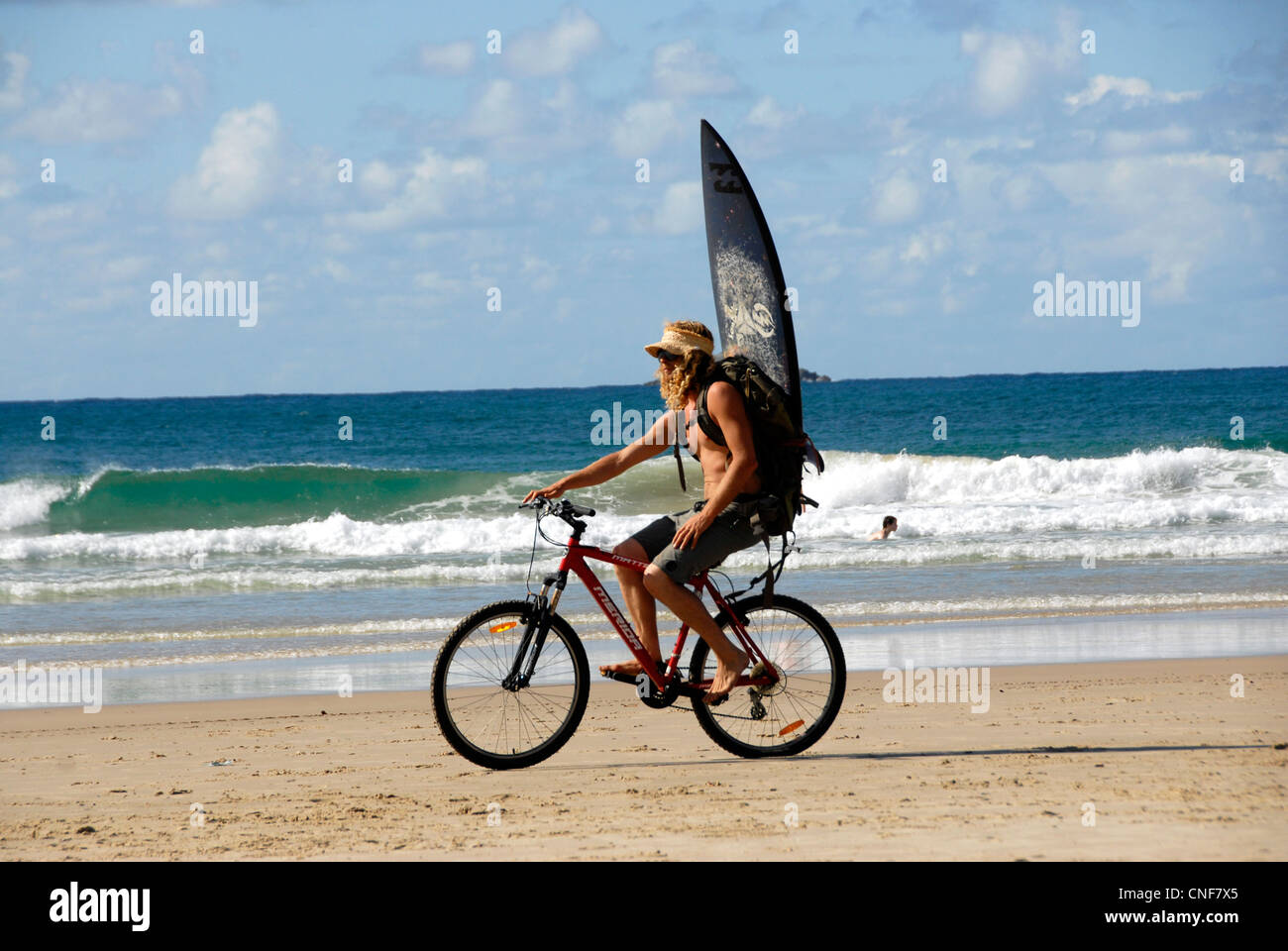 Surfer with surf board on back of his bike on Byron Bay main beach, NSW ...