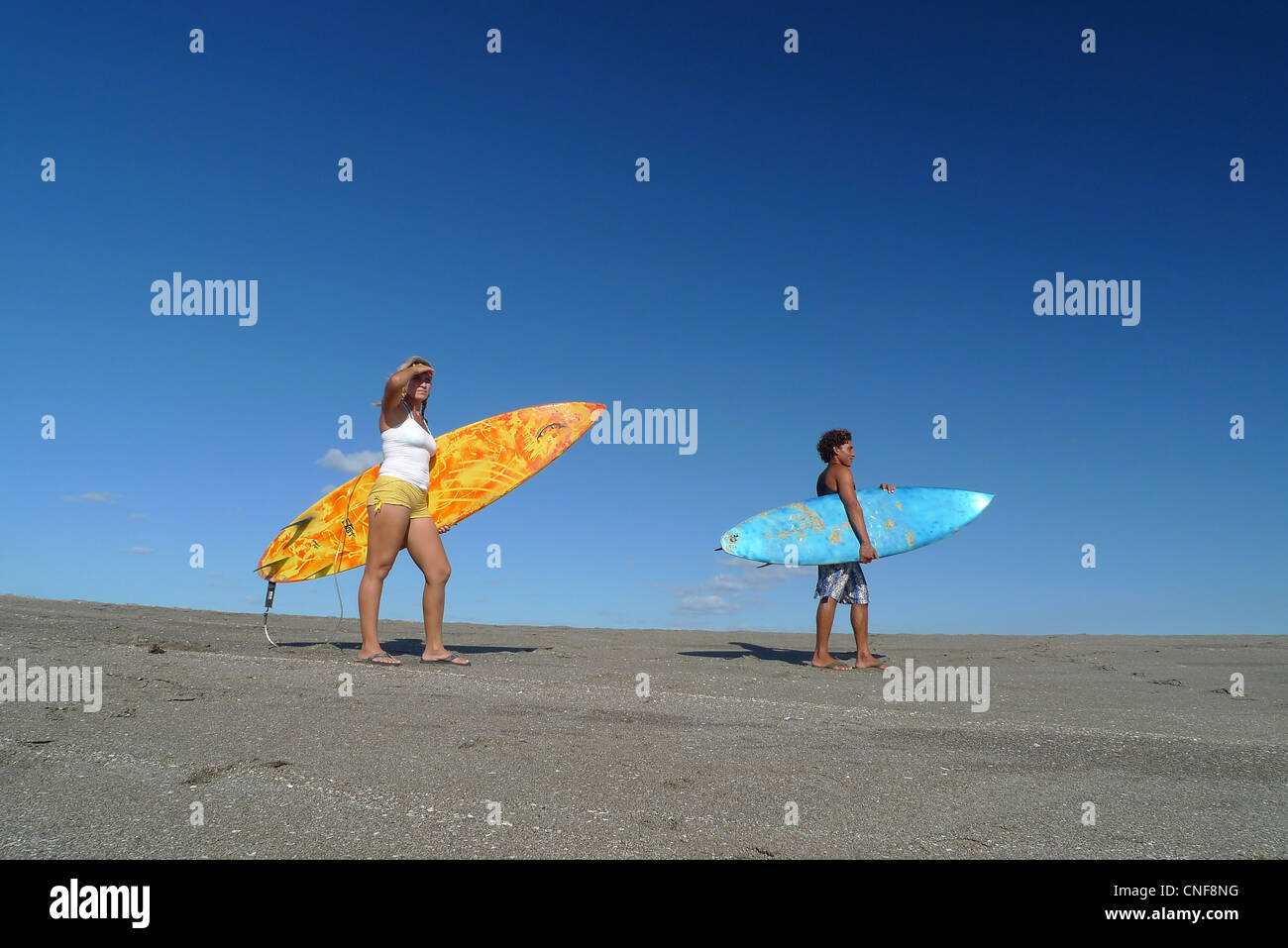 Surfers with surf board looking for the right pacific ocean wave copy ...