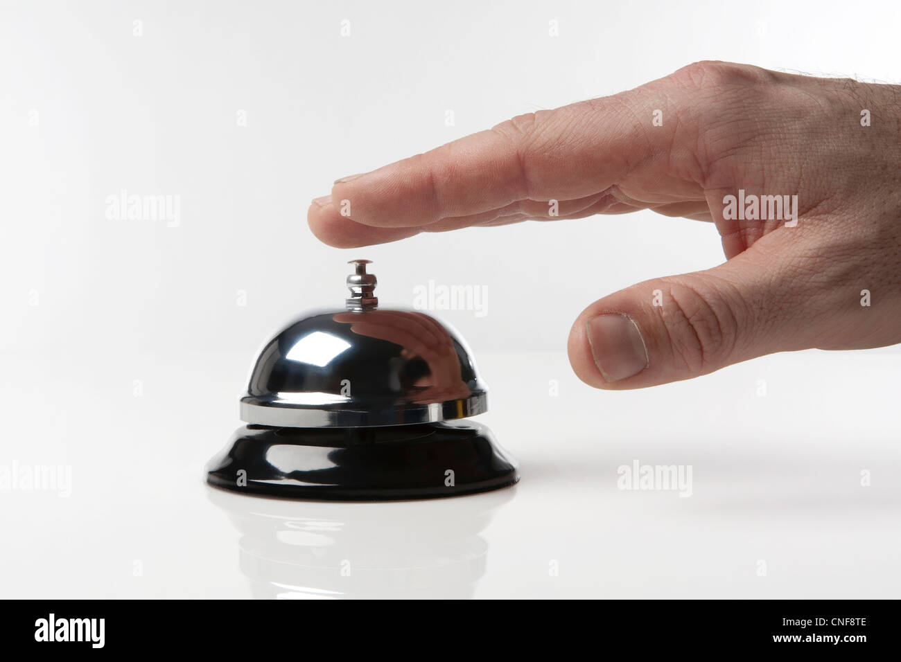 someone's hand pressing a service bell what could they want Stock Photo ...