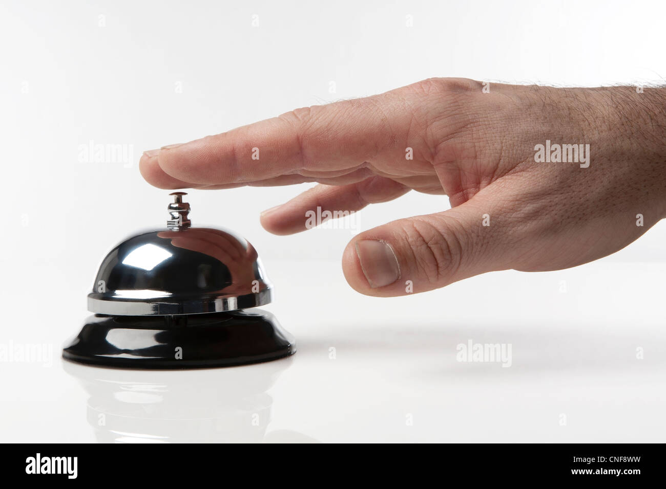 someone's hand pressing a service bell what could they want Stock Photo ...