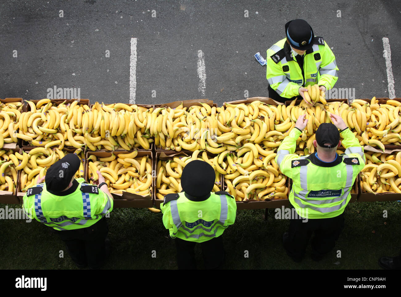 Police and cadets hand out bananas to runners at the finish line of the ...