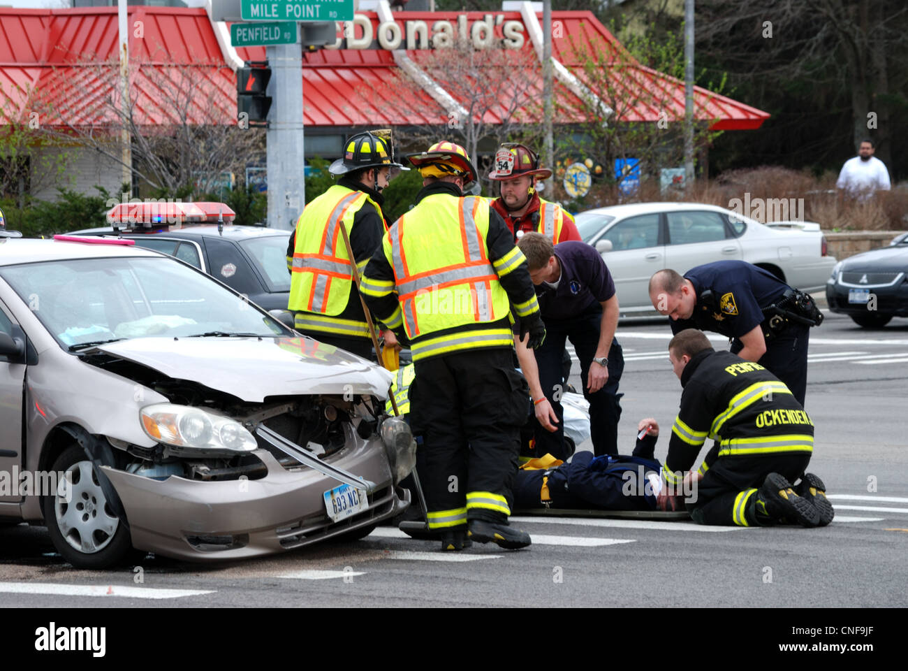 Firemen, policemen and emergency personnel prepare injured driver for ...