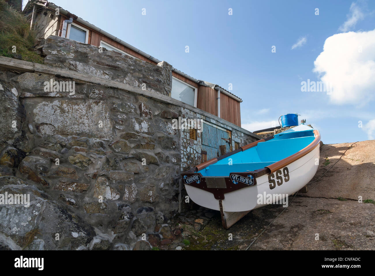 small fishing boat on slope next to small hut Stock Photo - Alamy