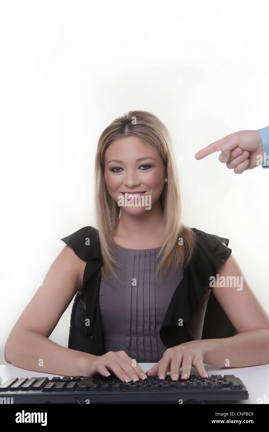 man hand pointing at a woman working at her desk Stock Photo - Alamy