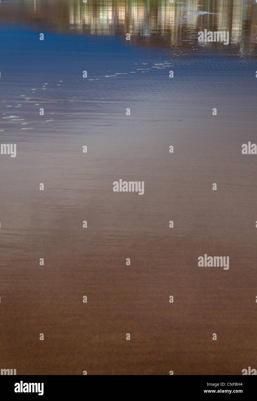 Reflection of seaside town on beach Stock Photo - Alamy