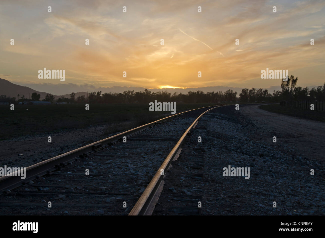 Photograph of a Sunset reflecting on old unused railroad tracks ...